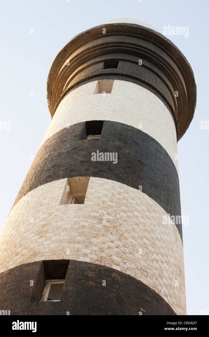 Top part of a black and white striped lighthouse tower against a blue ...