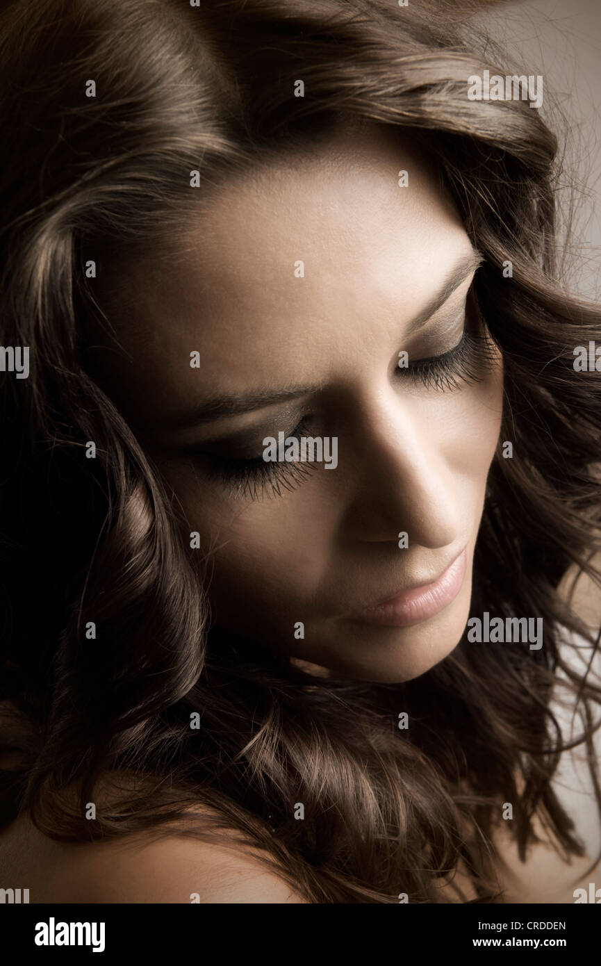 Portrait of a young woman with long eyelashes, looking down Stock Photo ...