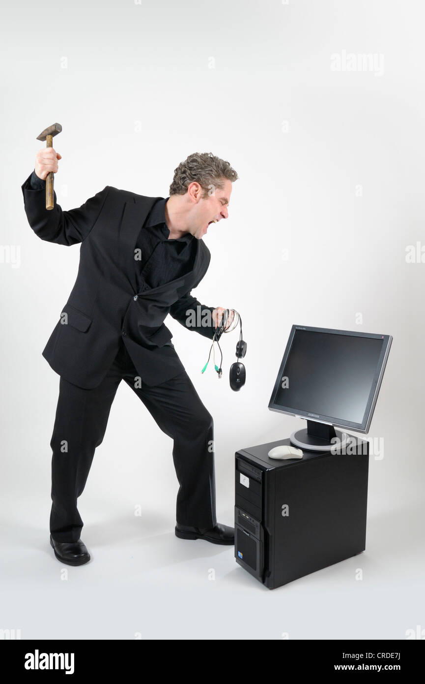 Young businessman hitting a computer with a hammer Stock Photo - Alamy