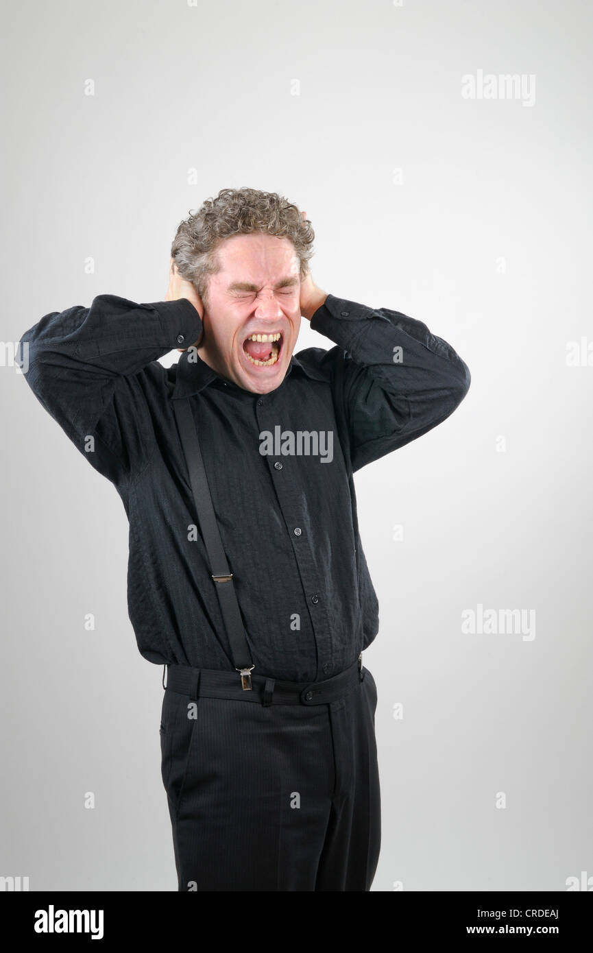 Businessman covering his ears screaming Stock Photo - Alamy