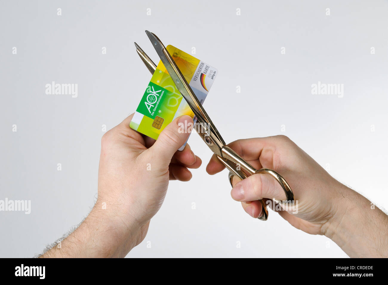 Hands cutting an old AOK health insurance card without a passport ...