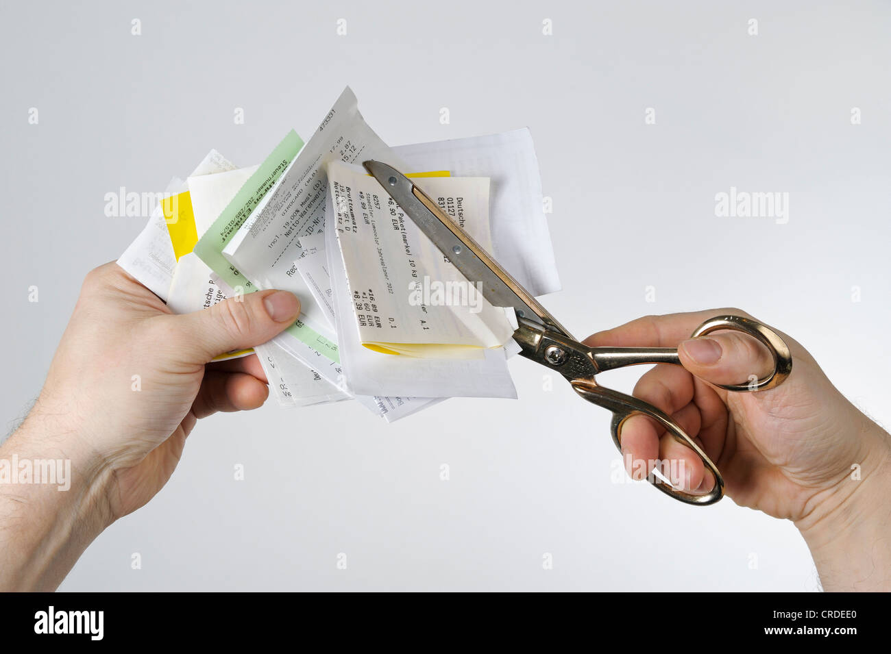 Hands cutting receipts with scissors Stock Photo - Alamy