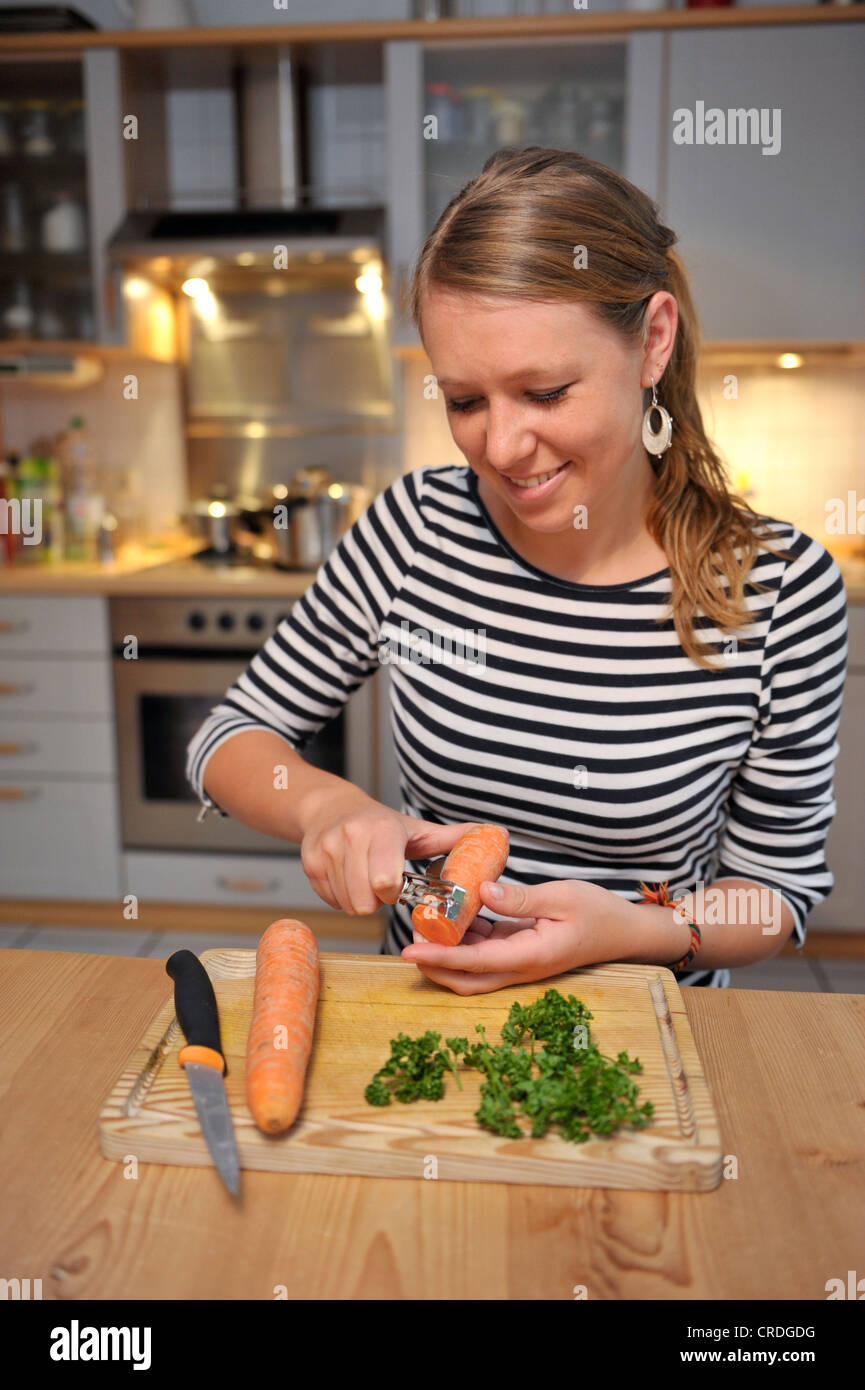 Young woman cutting vegetables in a kitchen Stock Photo - Alamy