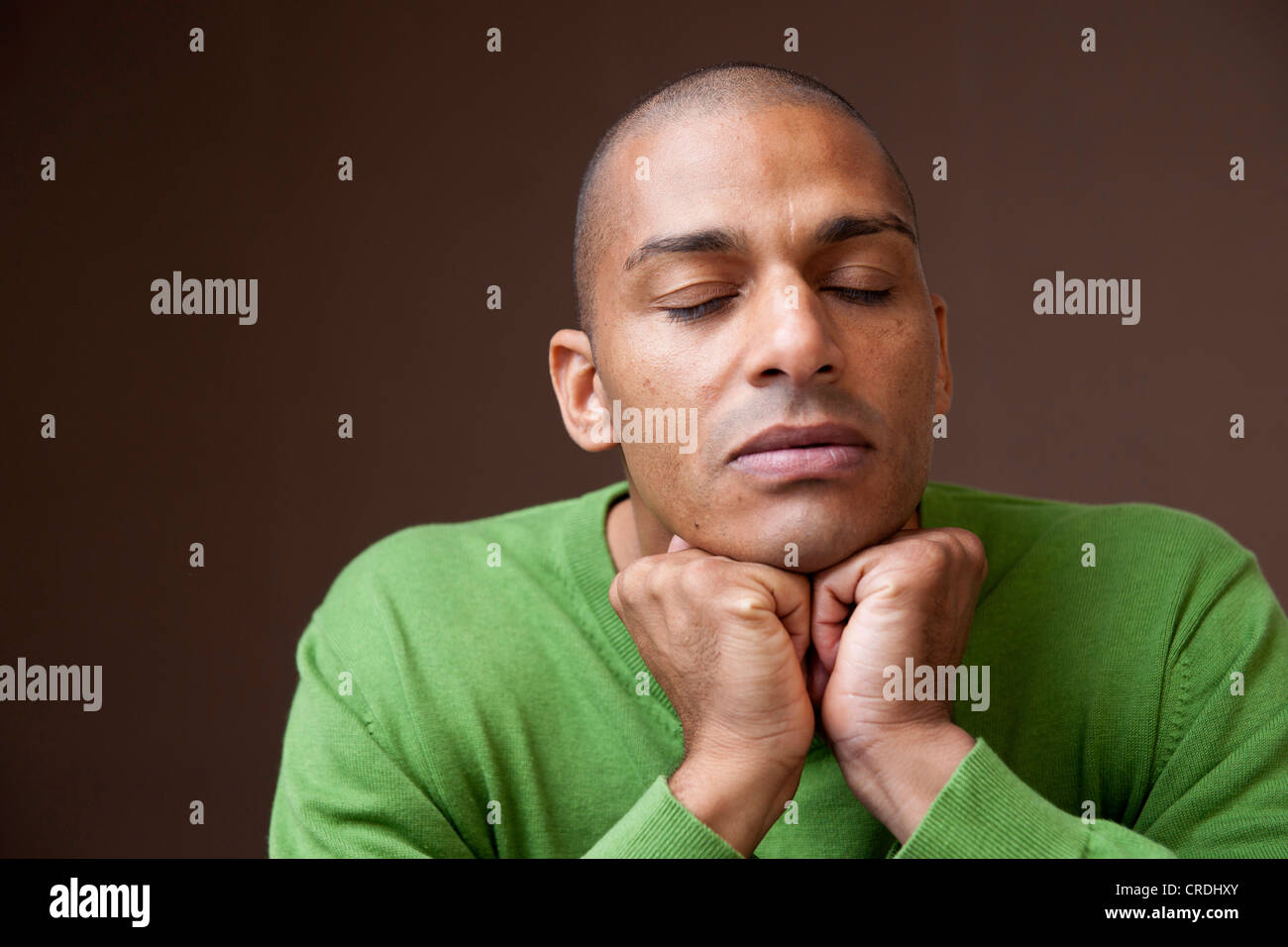 Young man, dark-skinned, head resting on hands, portraits Stock Photo ...