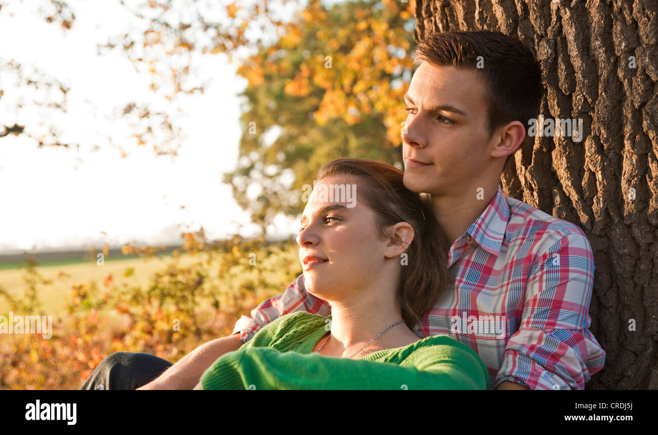 Man sitting against tree trunk hi-res stock photography and images - Alamy
