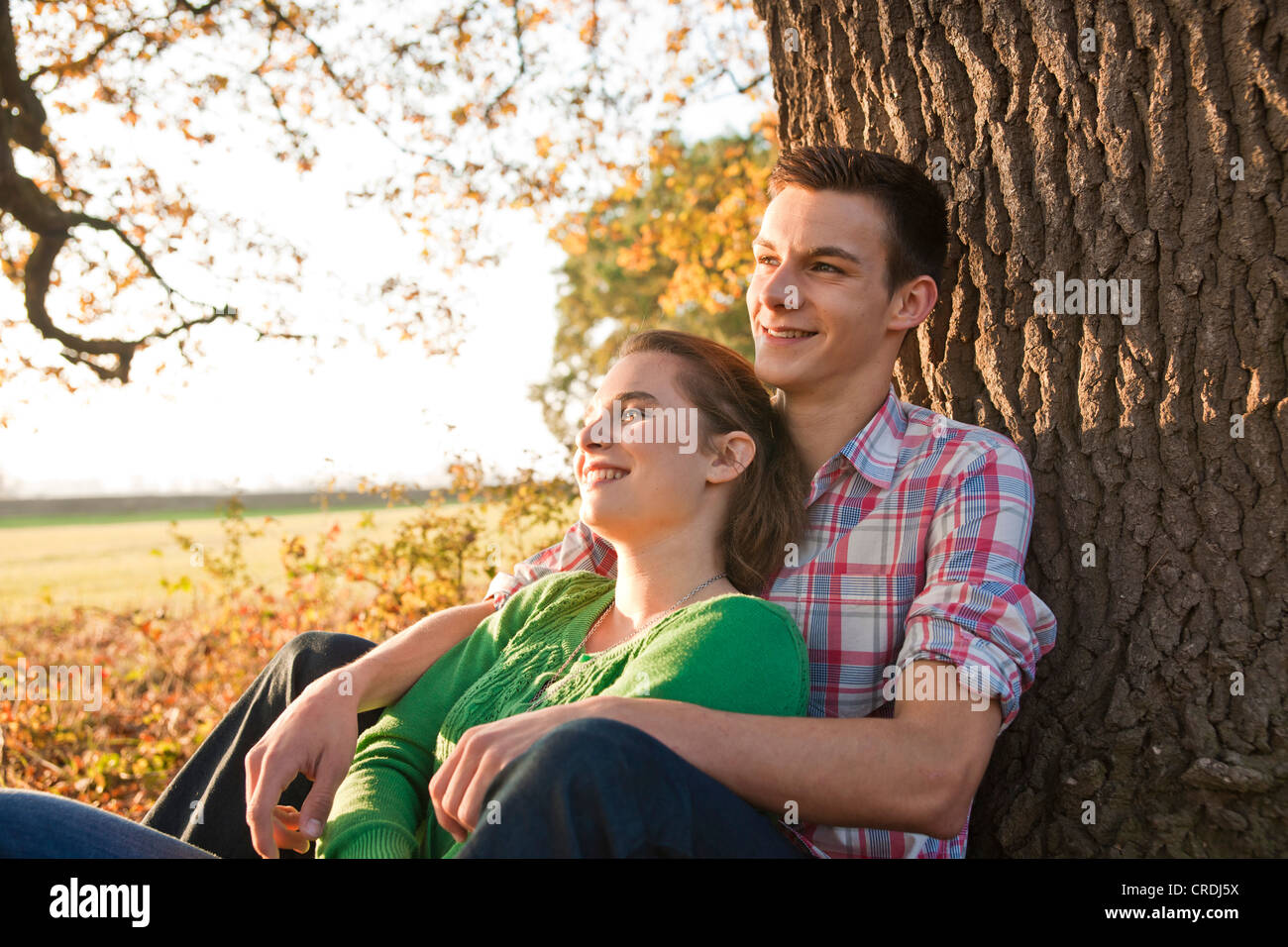 Couple leaning against a tree hi-res stock photography and images - Alamy