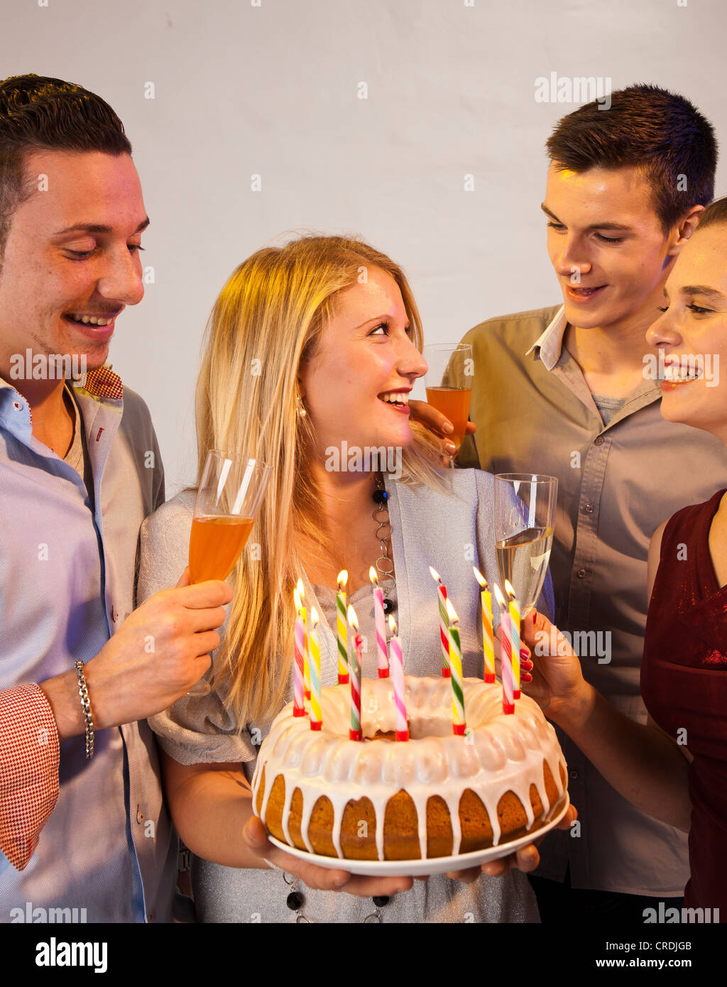 Group of young people celebrating with birthday cake Stock Photo - Alamy