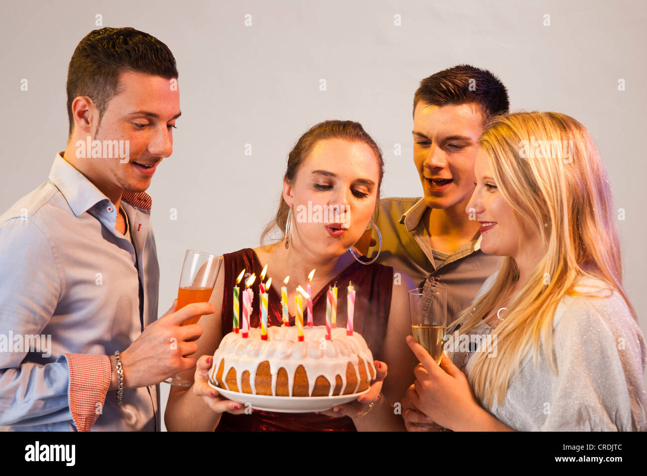 Group of young people celebrating with birthday cake Stock Photo - Alamy