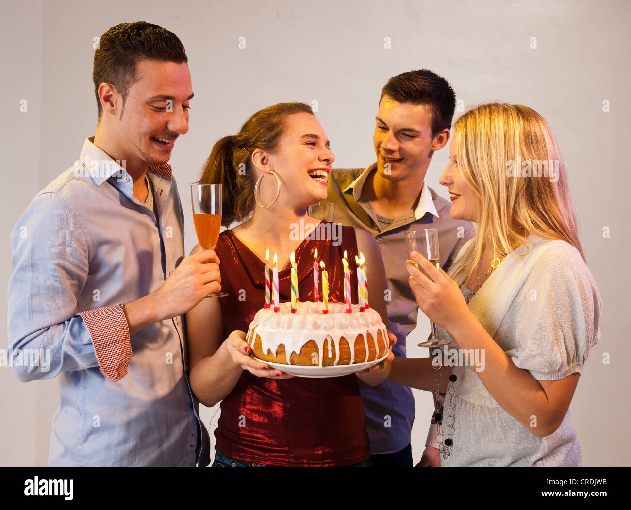 Group of young people celebrating with birthday cake Stock Photo - Alamy