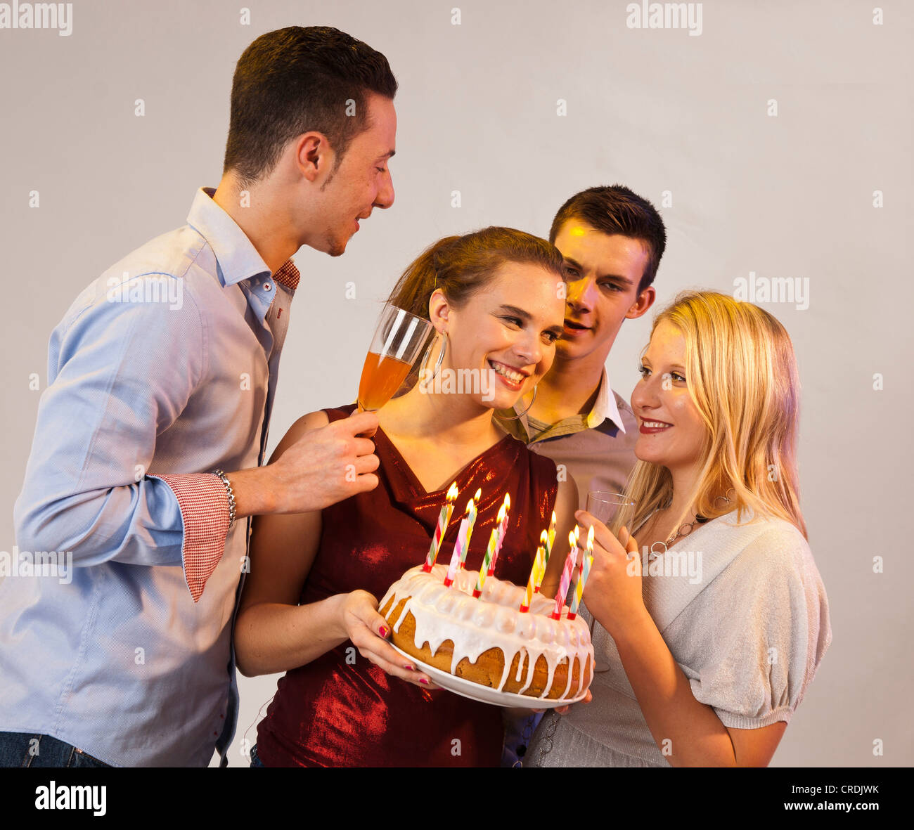 Group of young people celebrating with birthday cake Stock Photo - Alamy