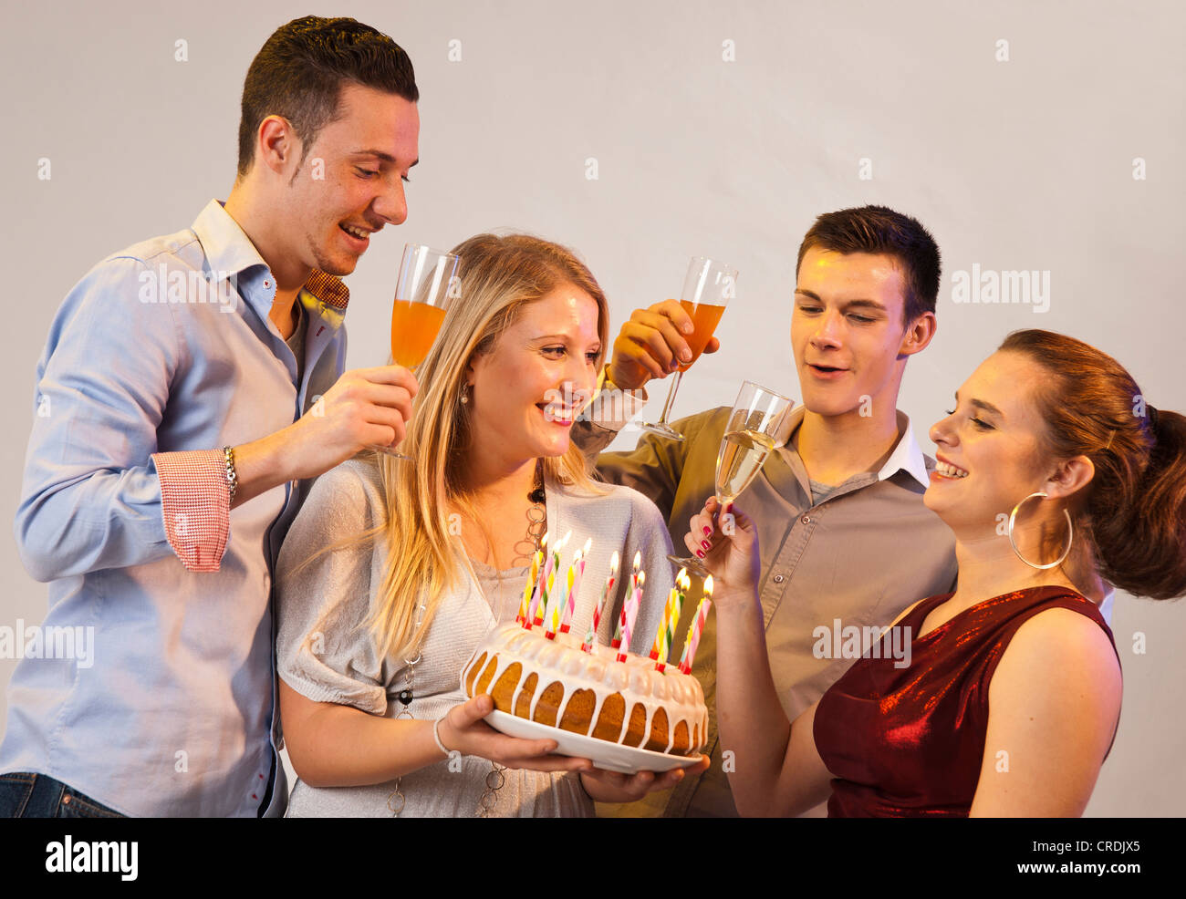 Group of young people celebrating with birthday cake Stock Photo - Alamy