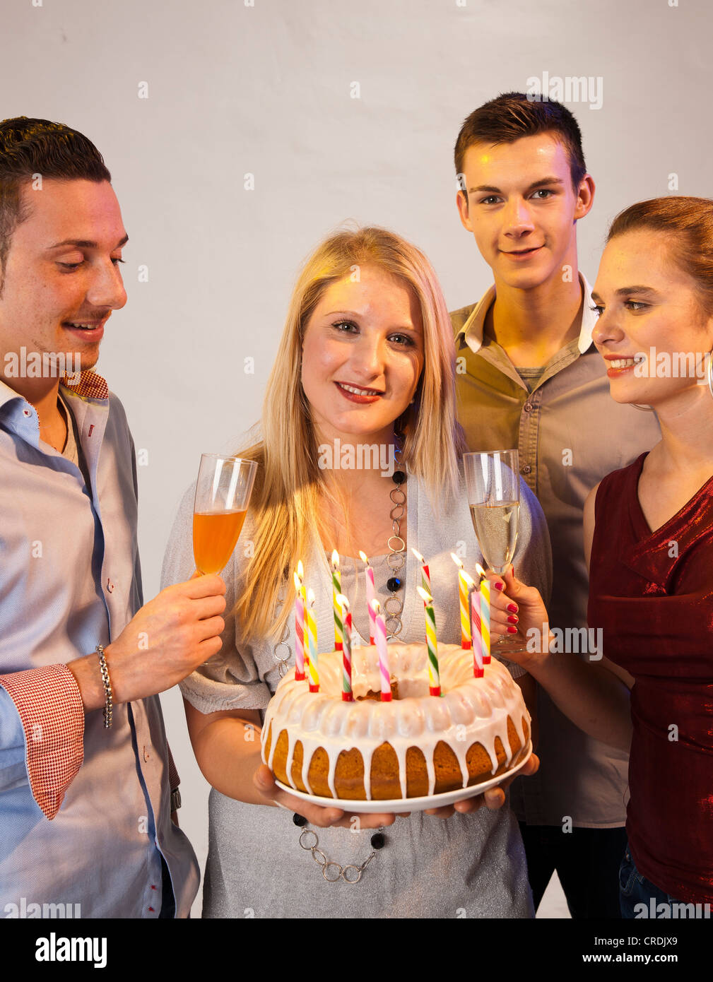 Group of young people celebrating with birthday cake Stock Photo - Alamy
