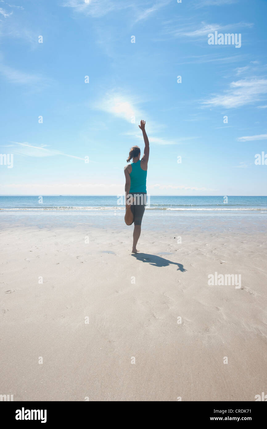Woman doing stretching exercises, gymnastics on the beach, Camaret-sur ...