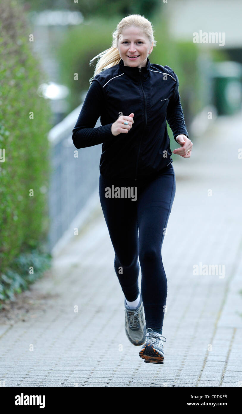 young woman at jogging, smiling at the camera Stock Photo - Alamy
