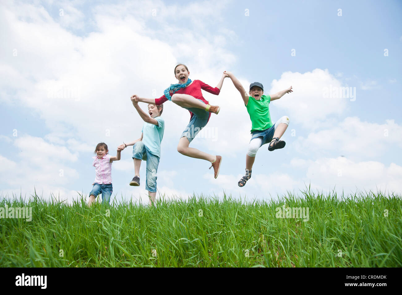 Four friends, three girls and a boy jumping into the air Stock Photo ...