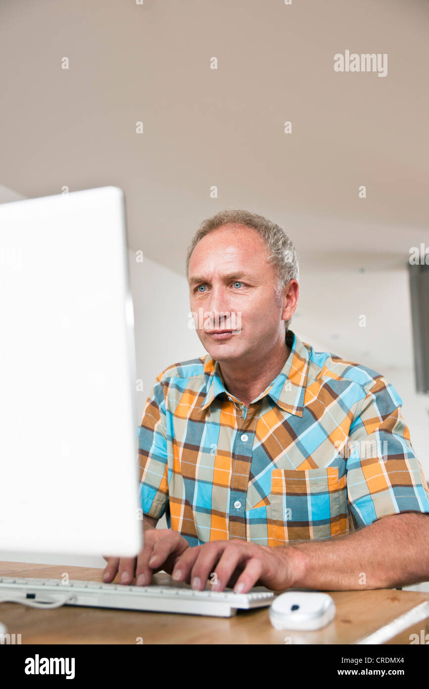 Man sitting in front of a computer Stock Photo - Alamy
