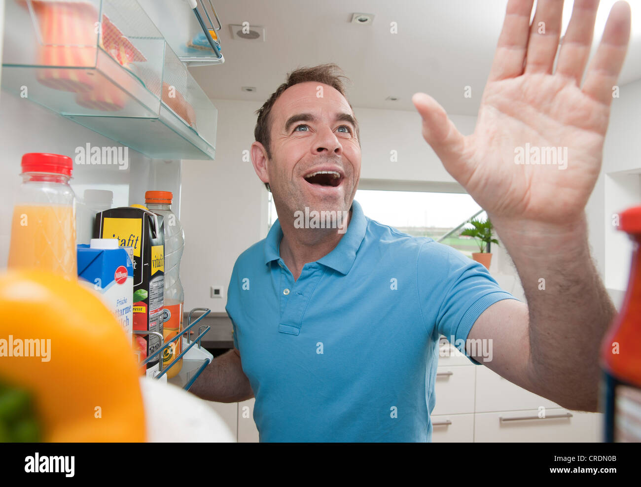 Smiling man opening a fridge Stock Photo - Alamy