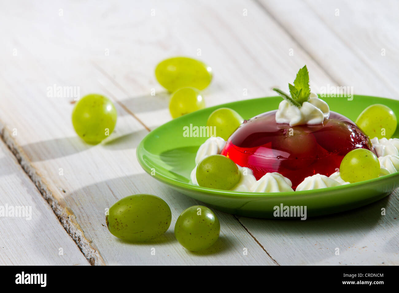 Red jelly and grapes served on a plate Stock Photo - Alamy