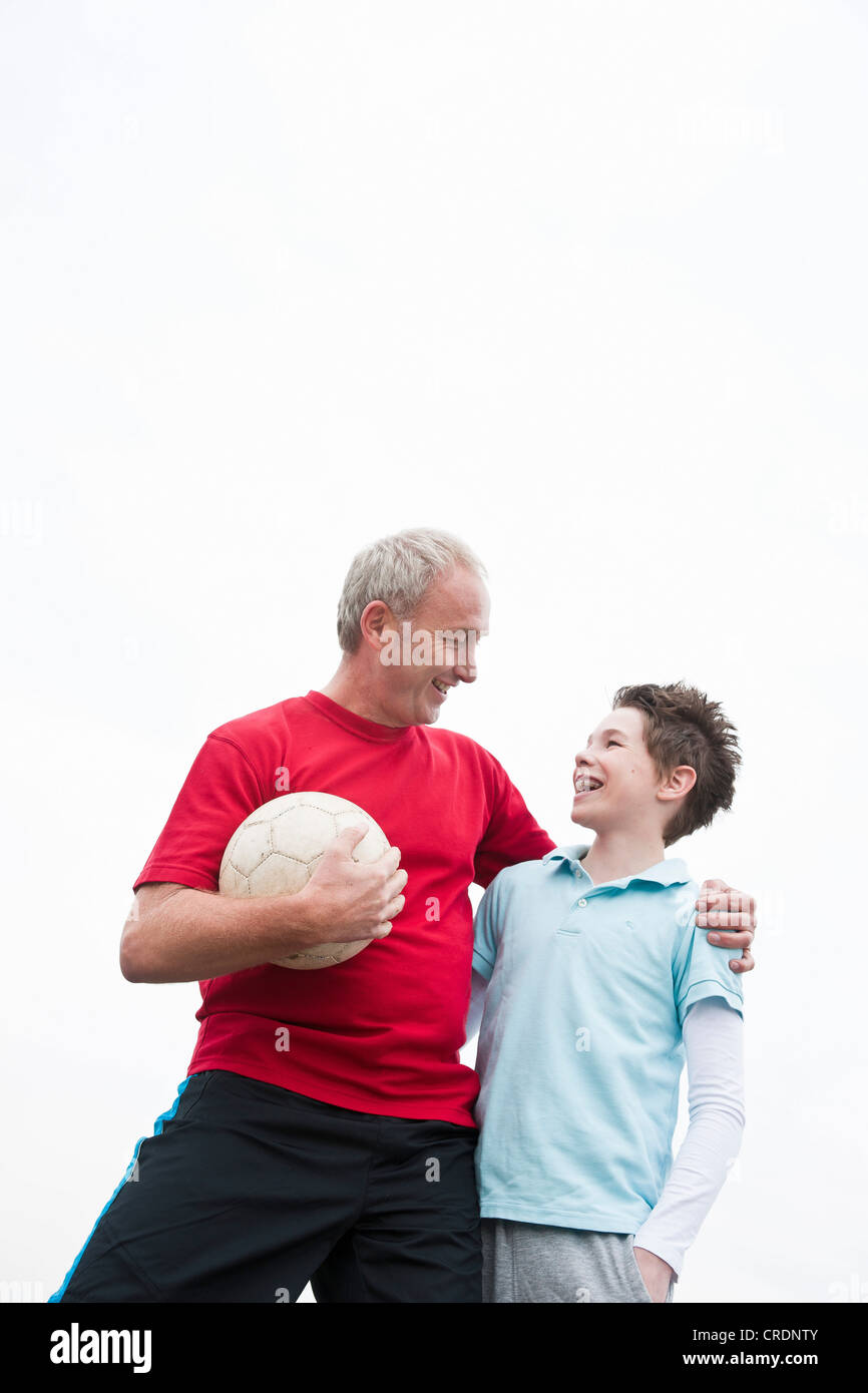 Father with football hugging his son Stock Photo - Alamy