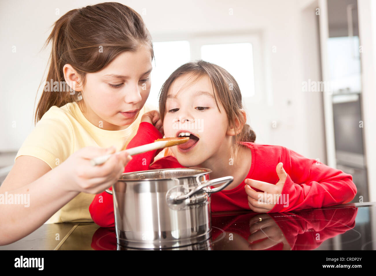 Two girls cooking together Stock Photo - Alamy