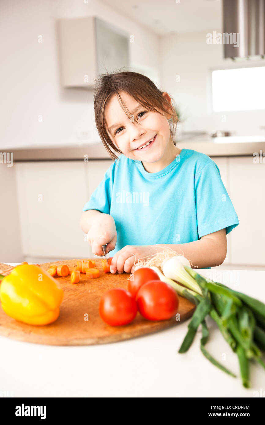 A little girl chopping vegetables Stock Photo - Alamy