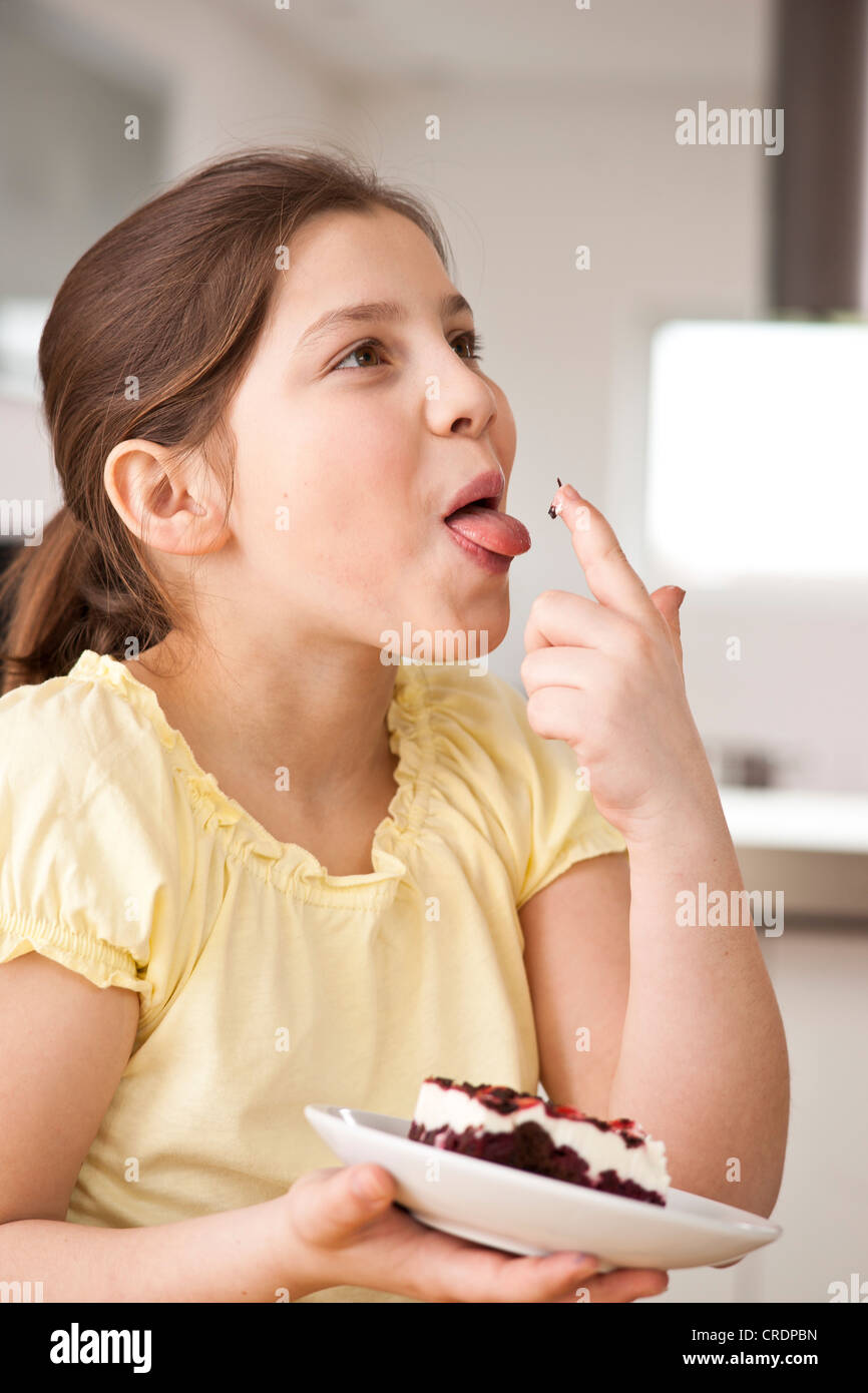 Girl nibbling on chocolate cake Stock Photo - Alamy