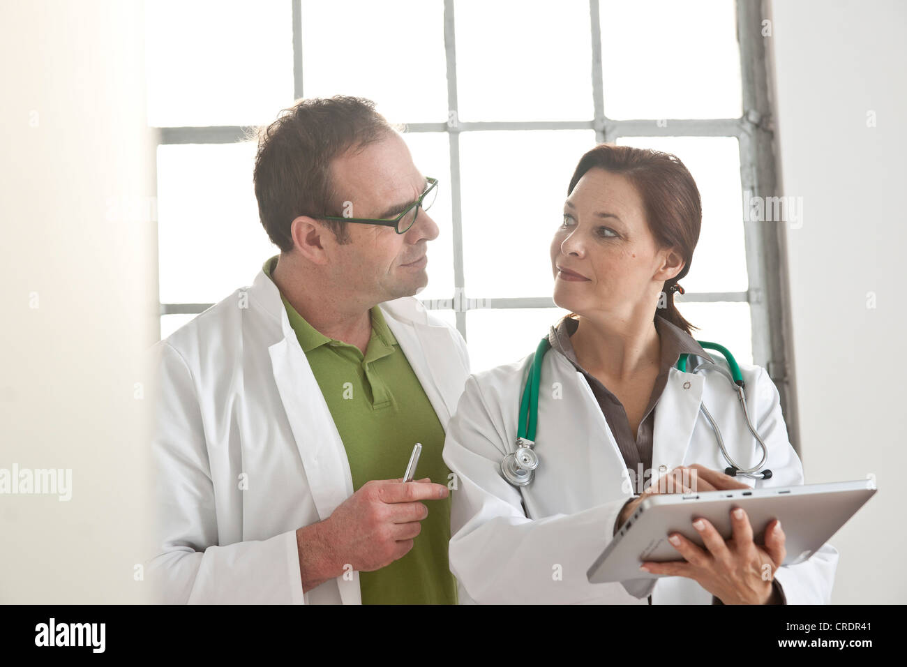 A male and a female doctor checking data on an iPad Stock Photo - Alamy
