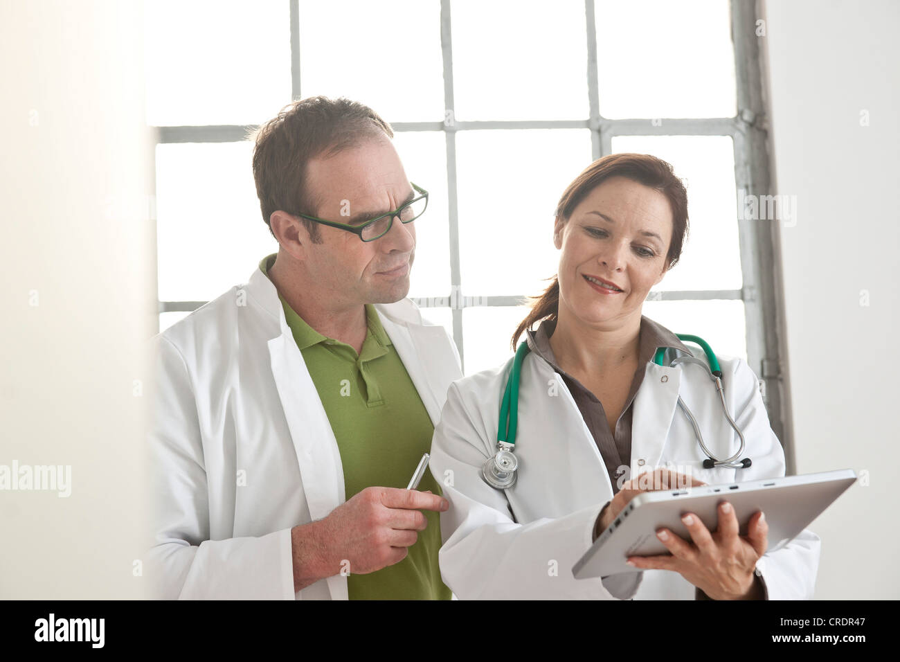 A male and a female doctor checking data on an iPad Stock Photo - Alamy