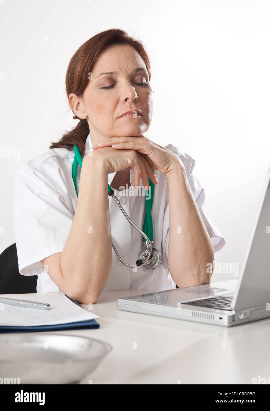 Tired doctor sitting in front of her computer Stock Photo - Alamy