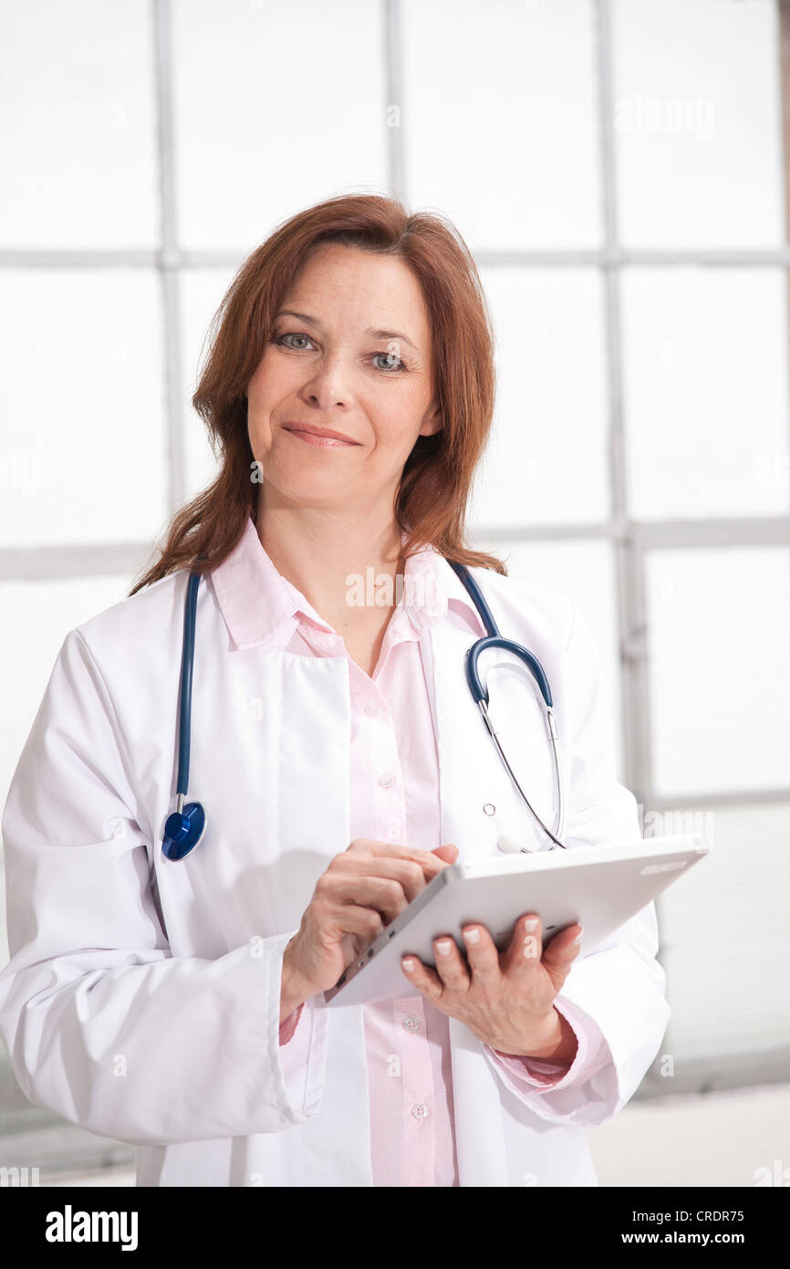 Smiling doctor holding an iPad Stock Photo - Alamy