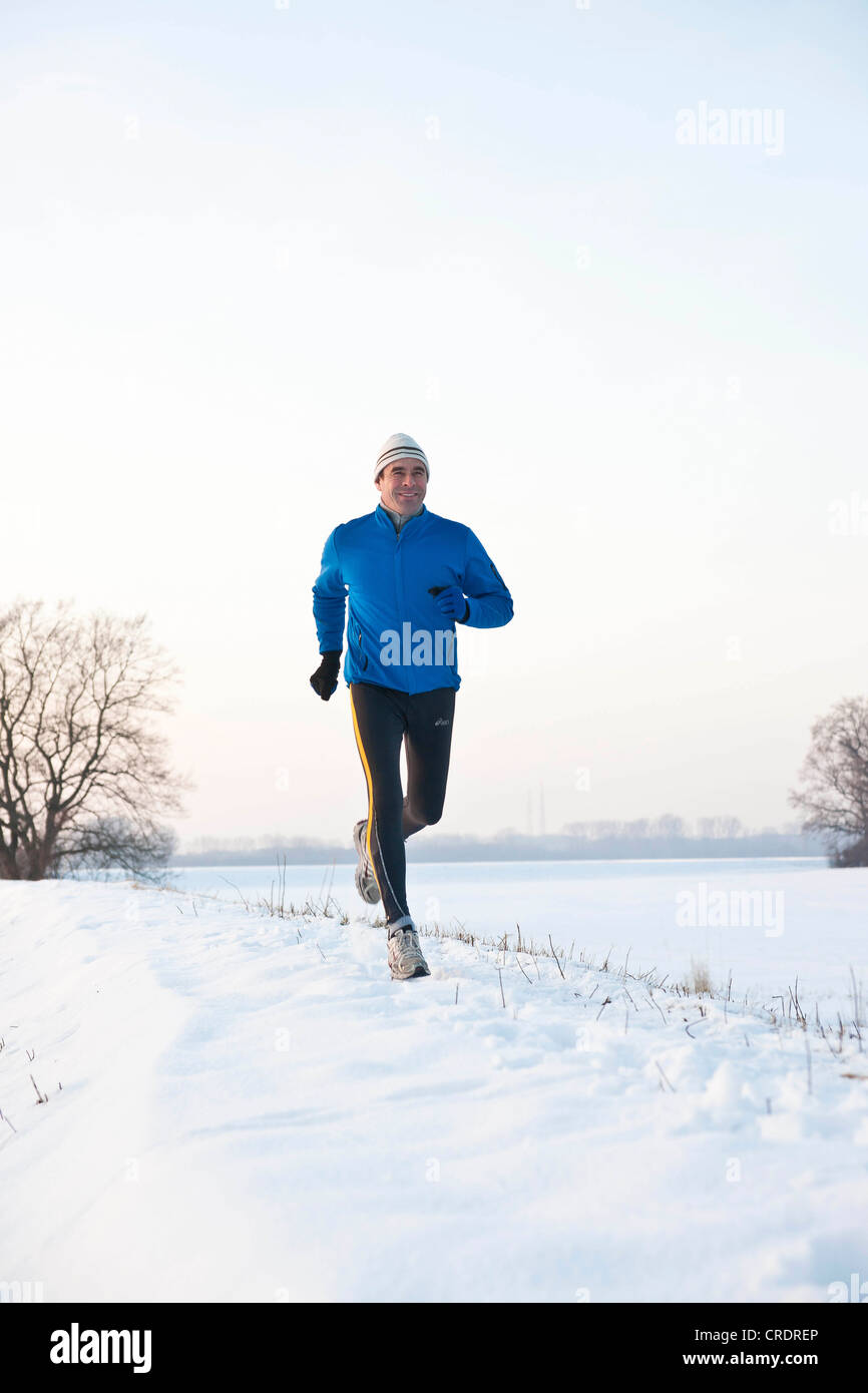 Man jogging in the snow Stock Photo - Alamy