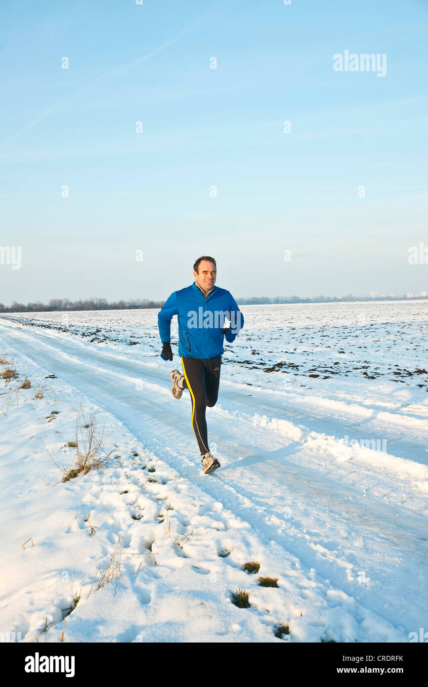 Man jogging in the snow Stock Photo - Alamy