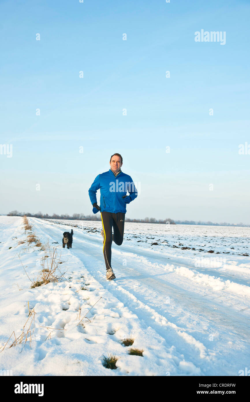 Man jogging in the snow Stock Photo - Alamy