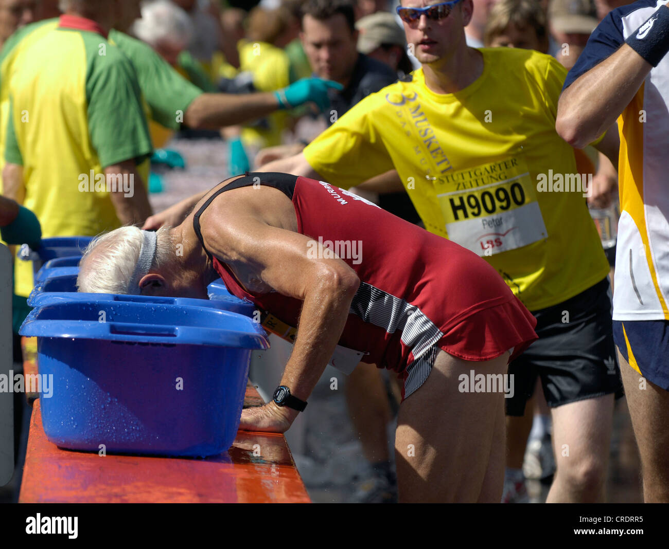 marathon, runner cooling down his head in water tank Stock Photo - Alamy