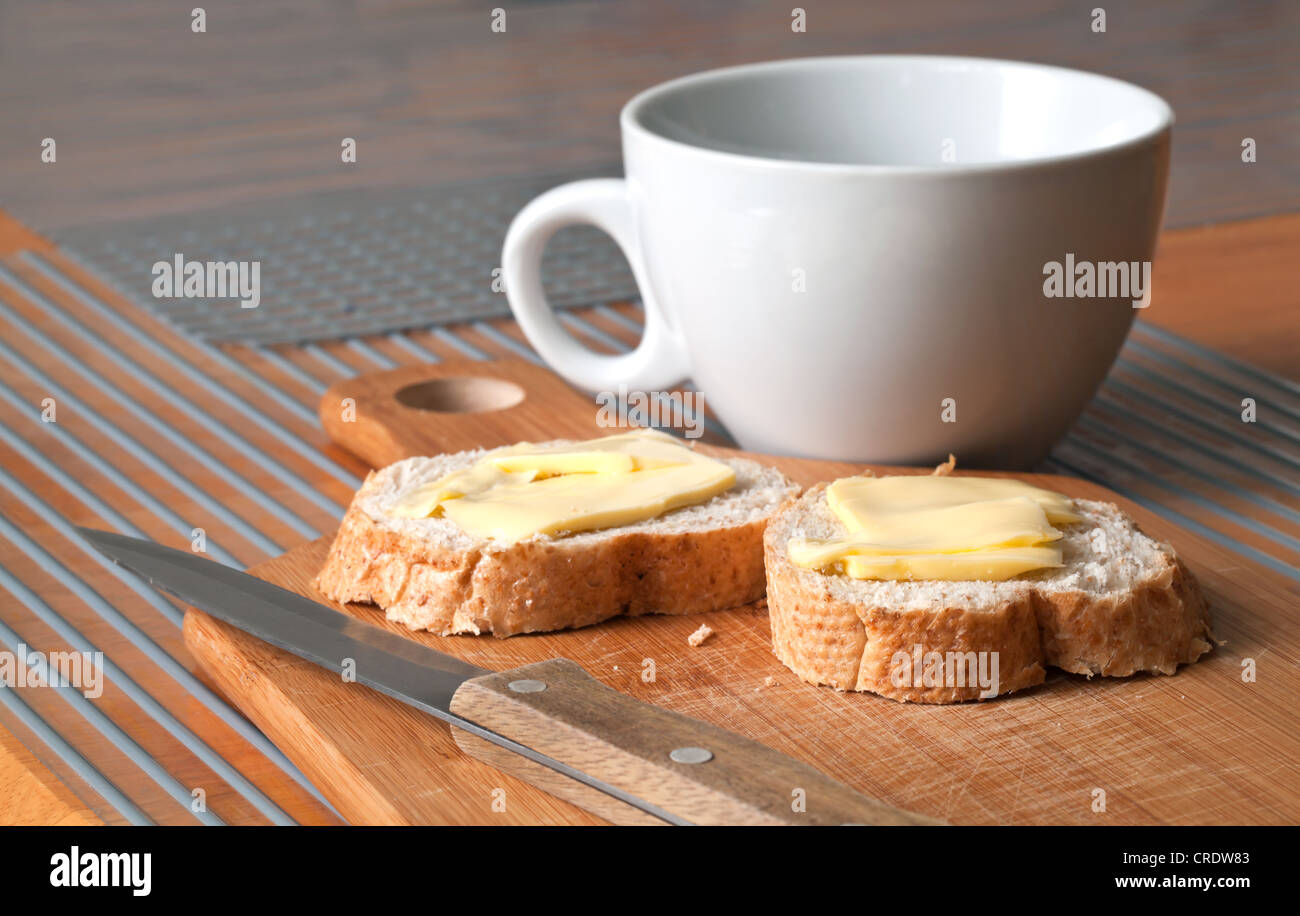Simple breakfast background with white tea cap and bread and butter ...