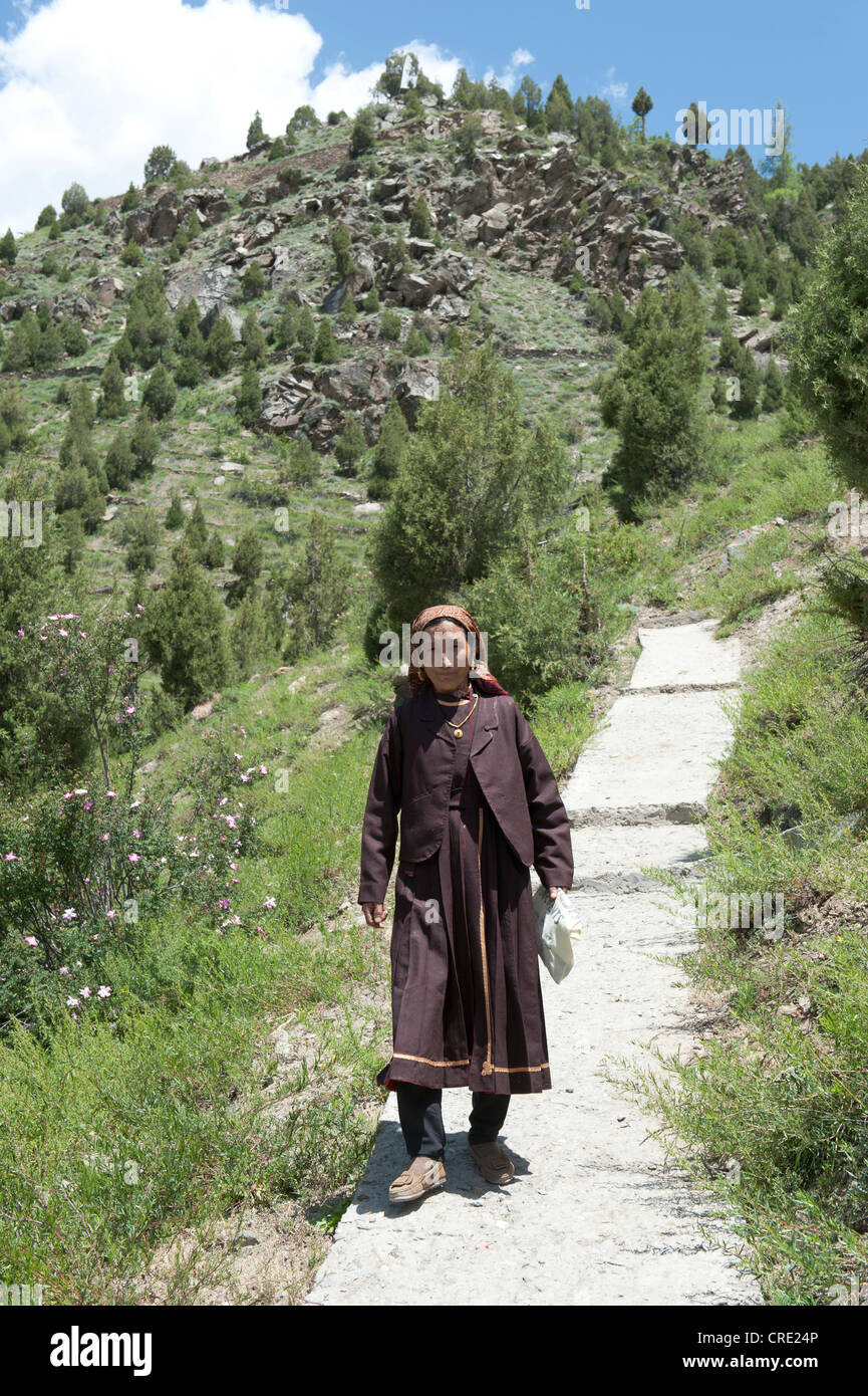 Woman wearing traditional clothes walking down the path from Shashur ...