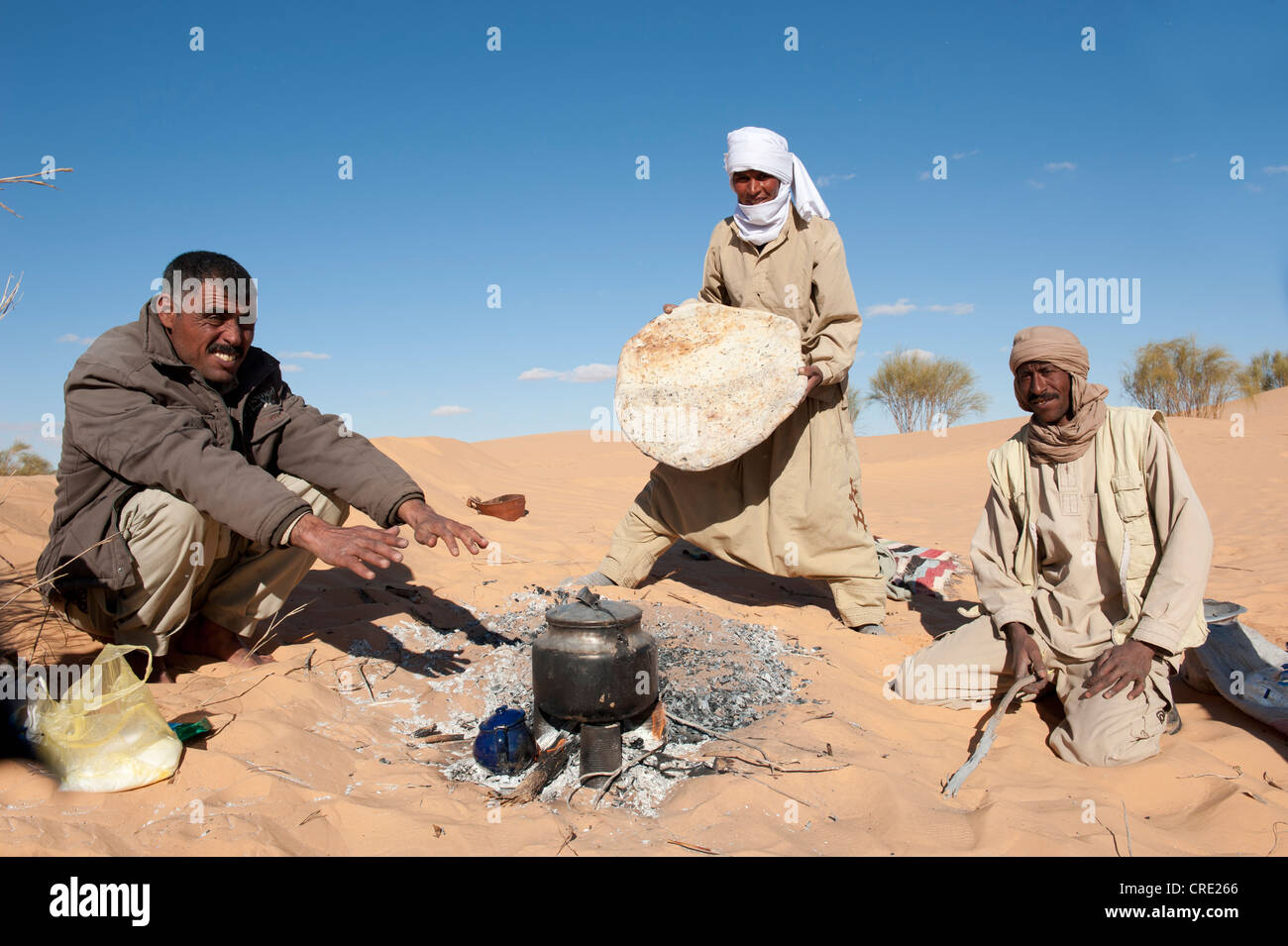 Bedouin baking sand bread, pita bread, sand dunes, Sahara desert ...