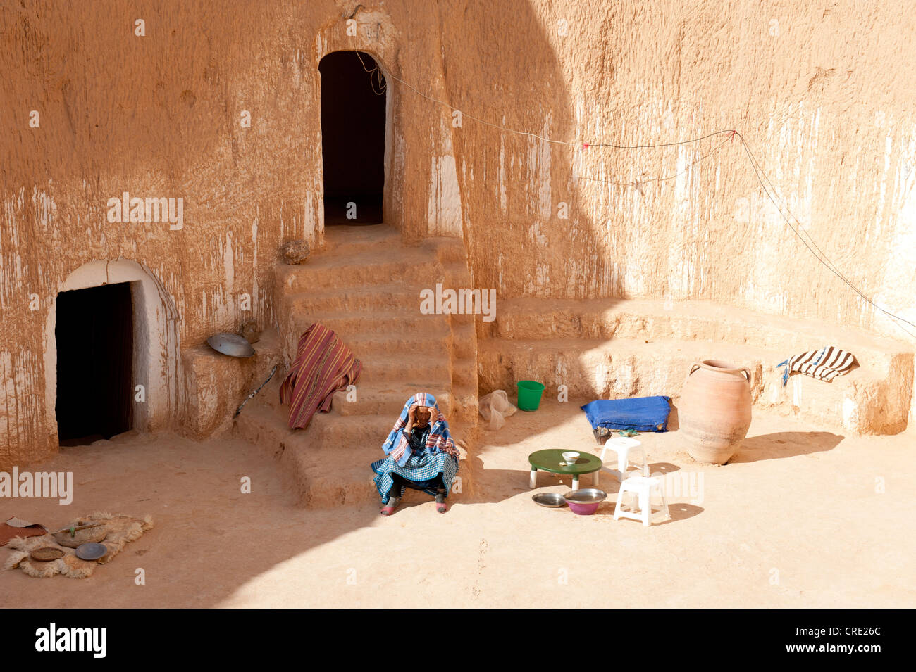 Berber woman dressed in traditional costume in a cave dwelling, Matmata ...