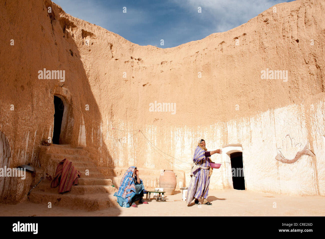 Two Berber women dressed in traditional costume in a cave dwelling ...