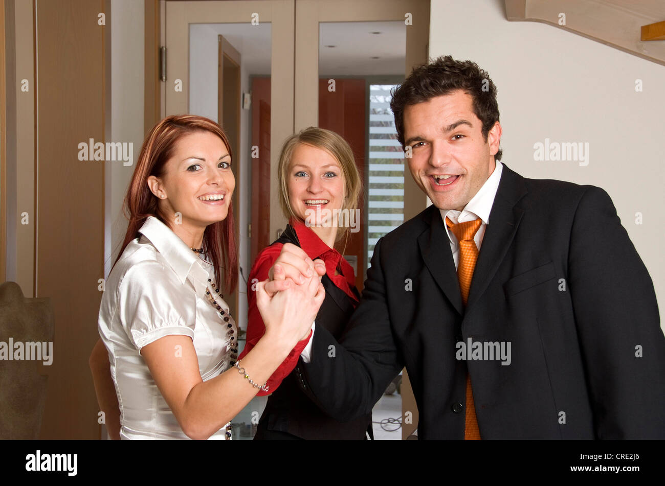three young successful business people cheering Stock Photo - Alamy