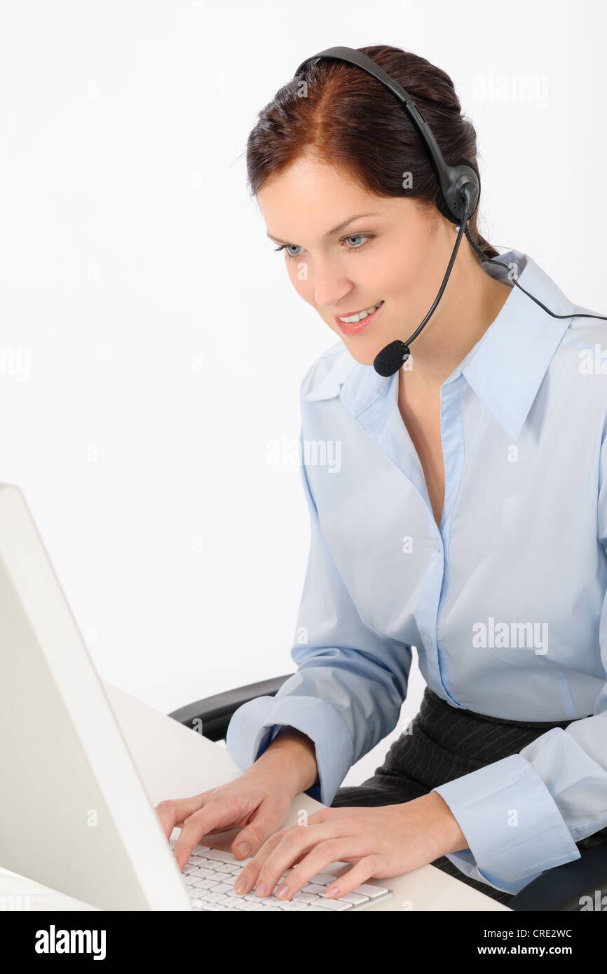 Friendly help desk woman at call center sitting behind computer Stock ...