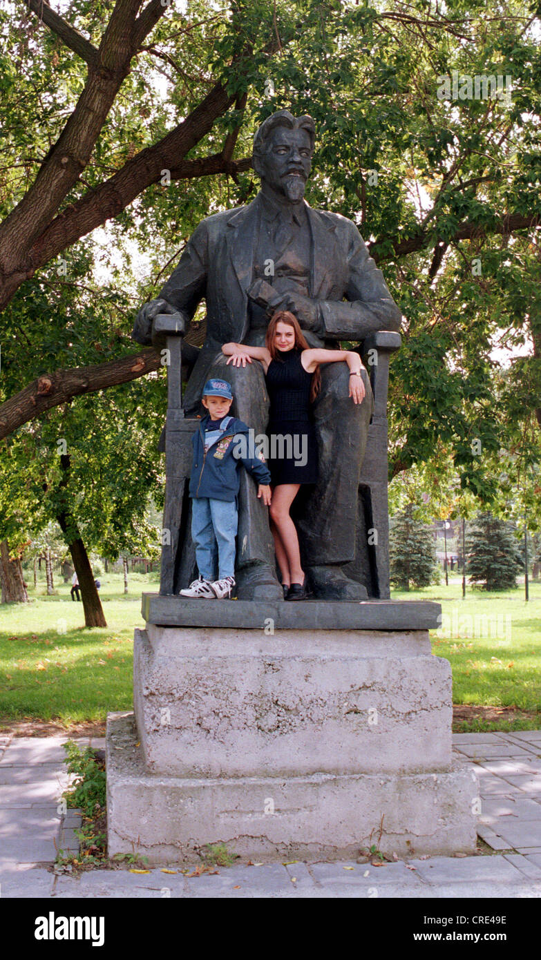 Young girl with her brother in front of a statue Stock Photo - Alamy