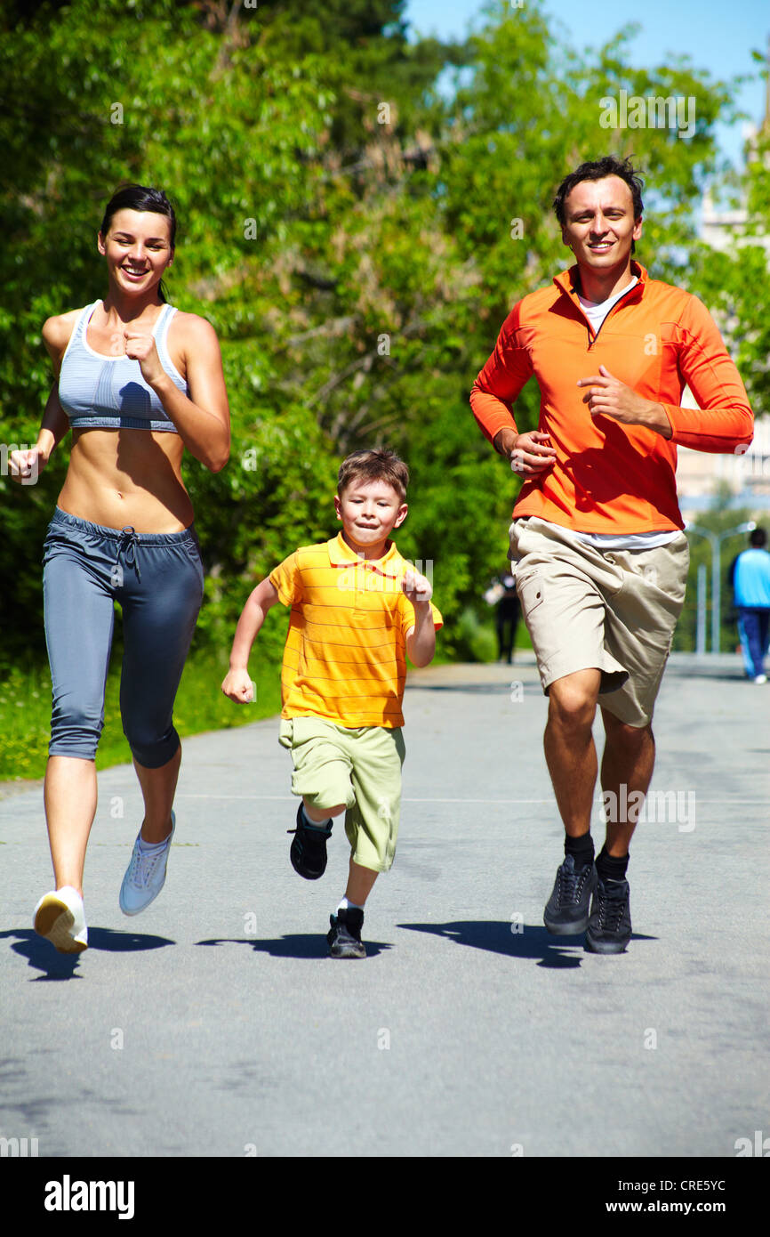 Vertical shot of three cheerful runners Stock Photo - Alamy