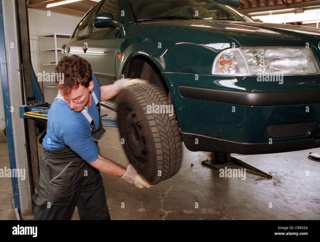 Auto mechanics when changing a tire, Berlin, Germany Stock Photo - Alamy