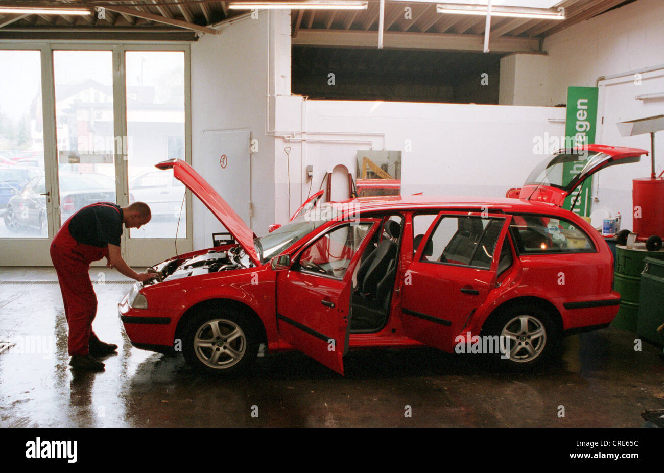 Mechanic screwed in the engine compartment of a car, Berlin, Germany ...