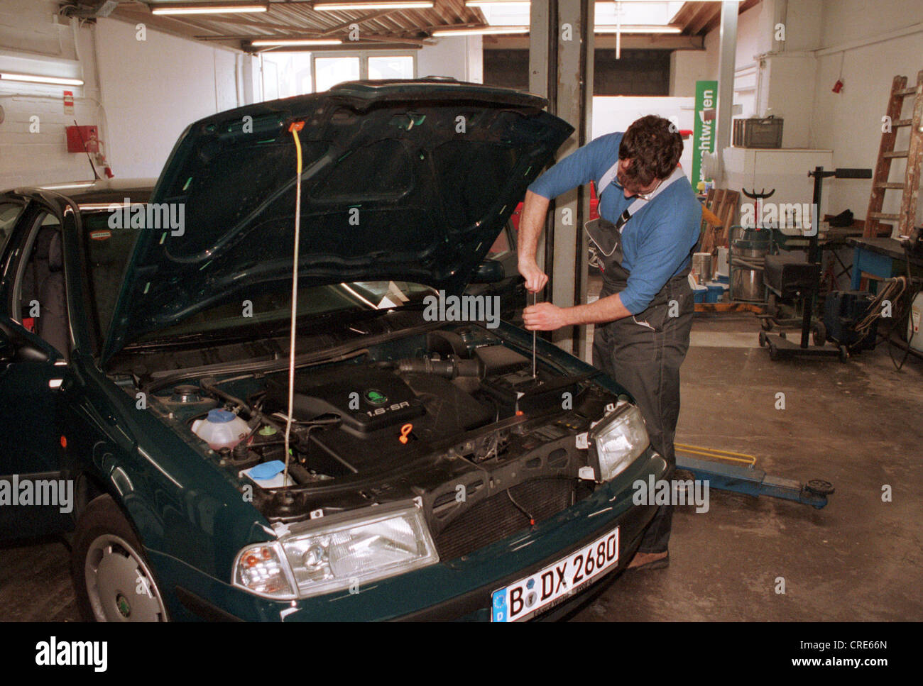 Mechanic screwed in the engine compartment of a car, Berlin, Germany ...