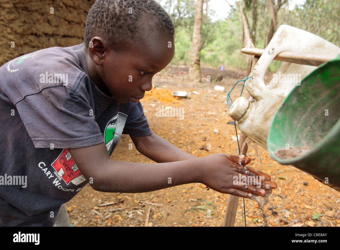 A boy washes his hands at a pedal-activated hand washing station ...