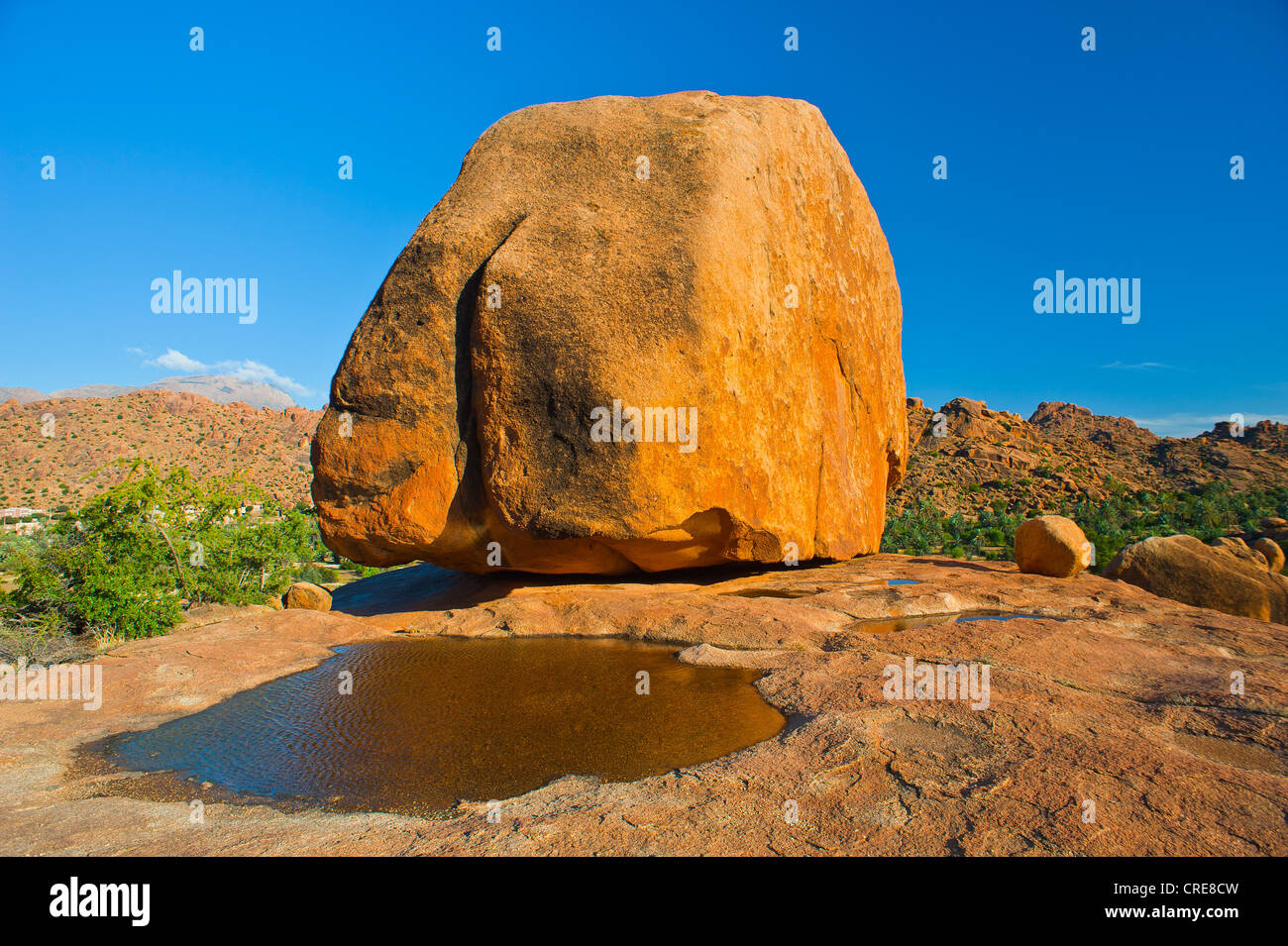 Huge granite boulder and a puddle of water on a ledge in the Anti-Atlas ...