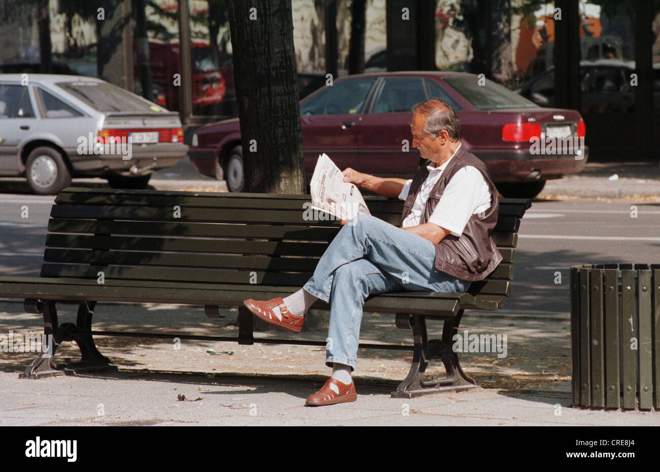 Newspaper readers on a park bench, Berlin, Germany Stock Photo - Alamy