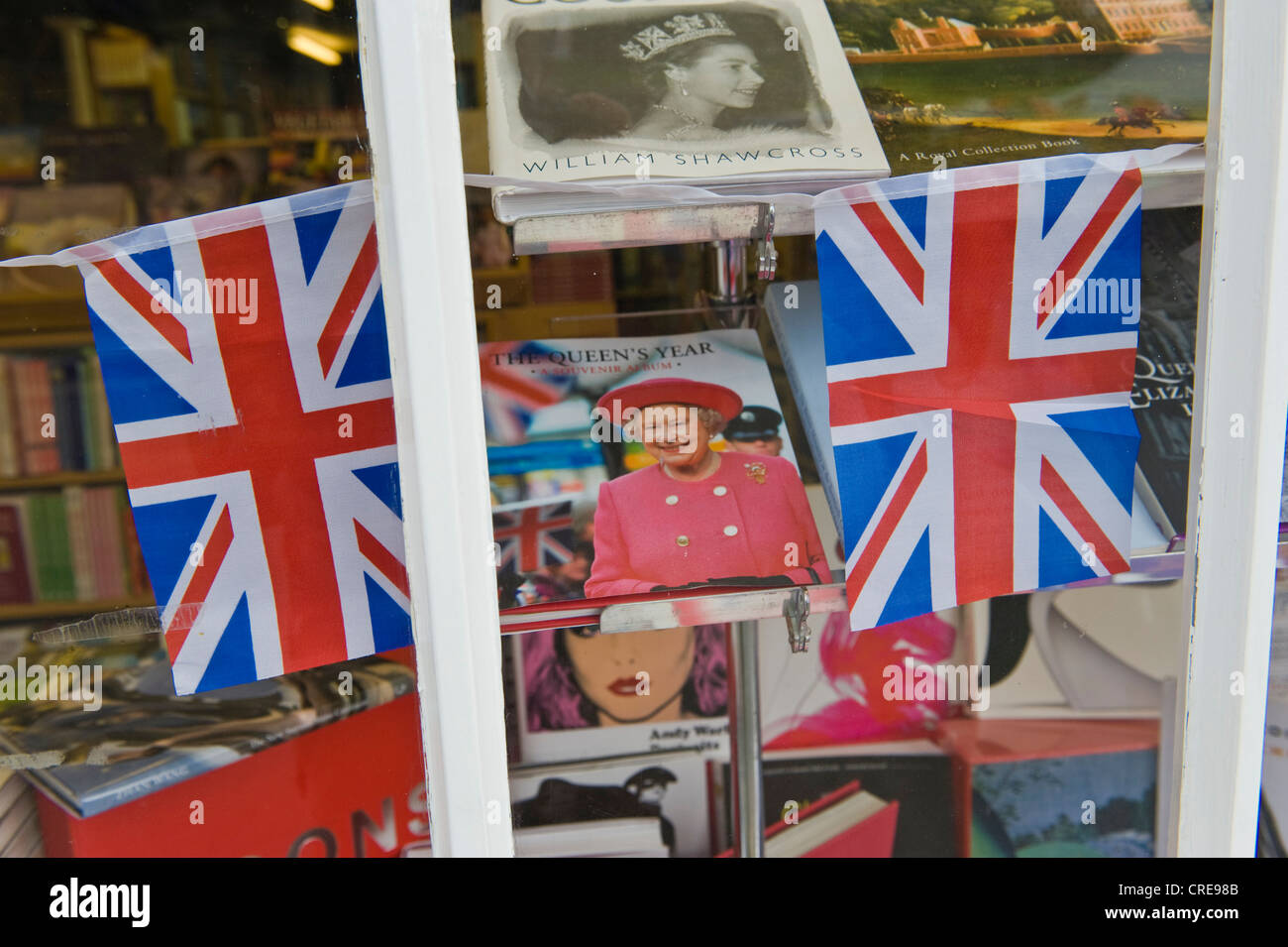 Union Jack flag bunting with Queen book in window of bookshop during ...